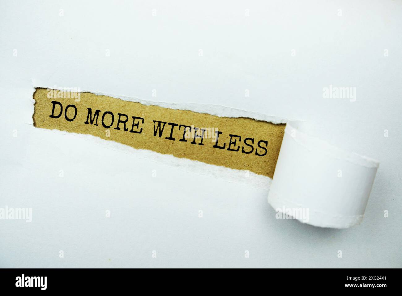 Do more with less message written on craft paper with torn paper ...