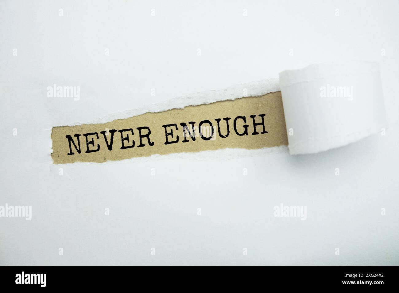 Never Enough message written on craft paper with torn paper background ...