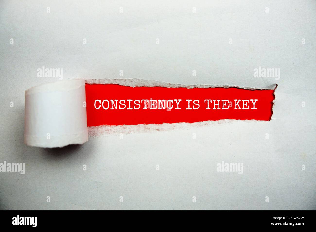 Consistency Is The Key message written on red paper with torn paper ...