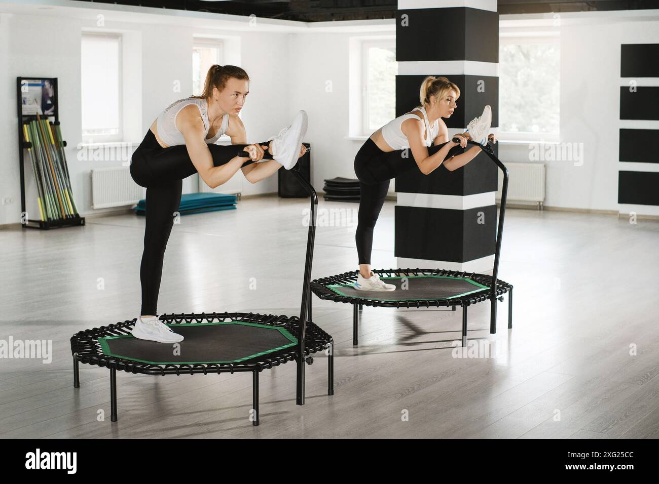 two-women-in-athletic-wear-perform-stretching-exercises-while-standing