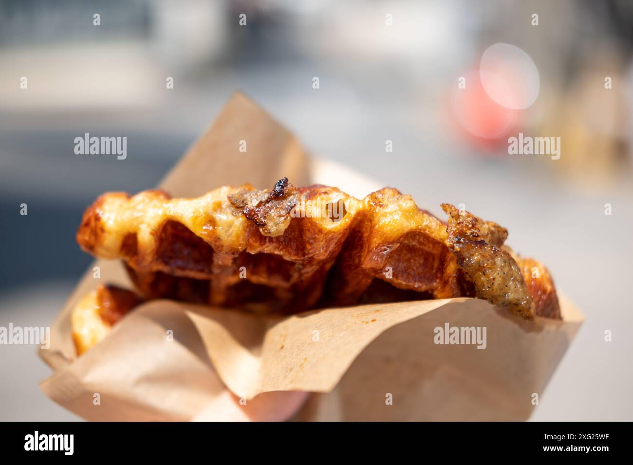 Hand holding Croffle with truffle. It is a hybrid of a croissant and ...