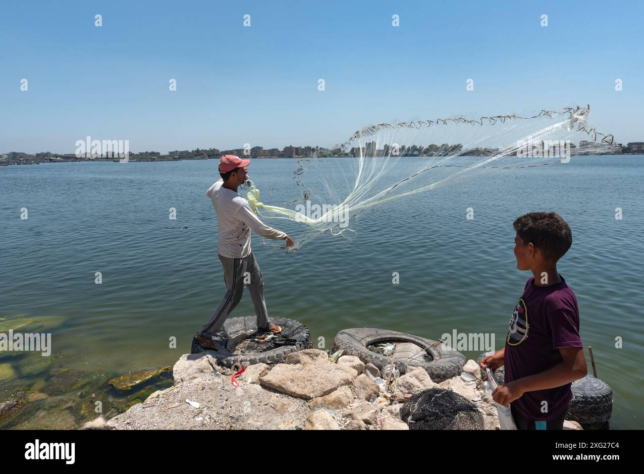 A local Egyptian fisherman castes his weighted net into the River Nile ...
