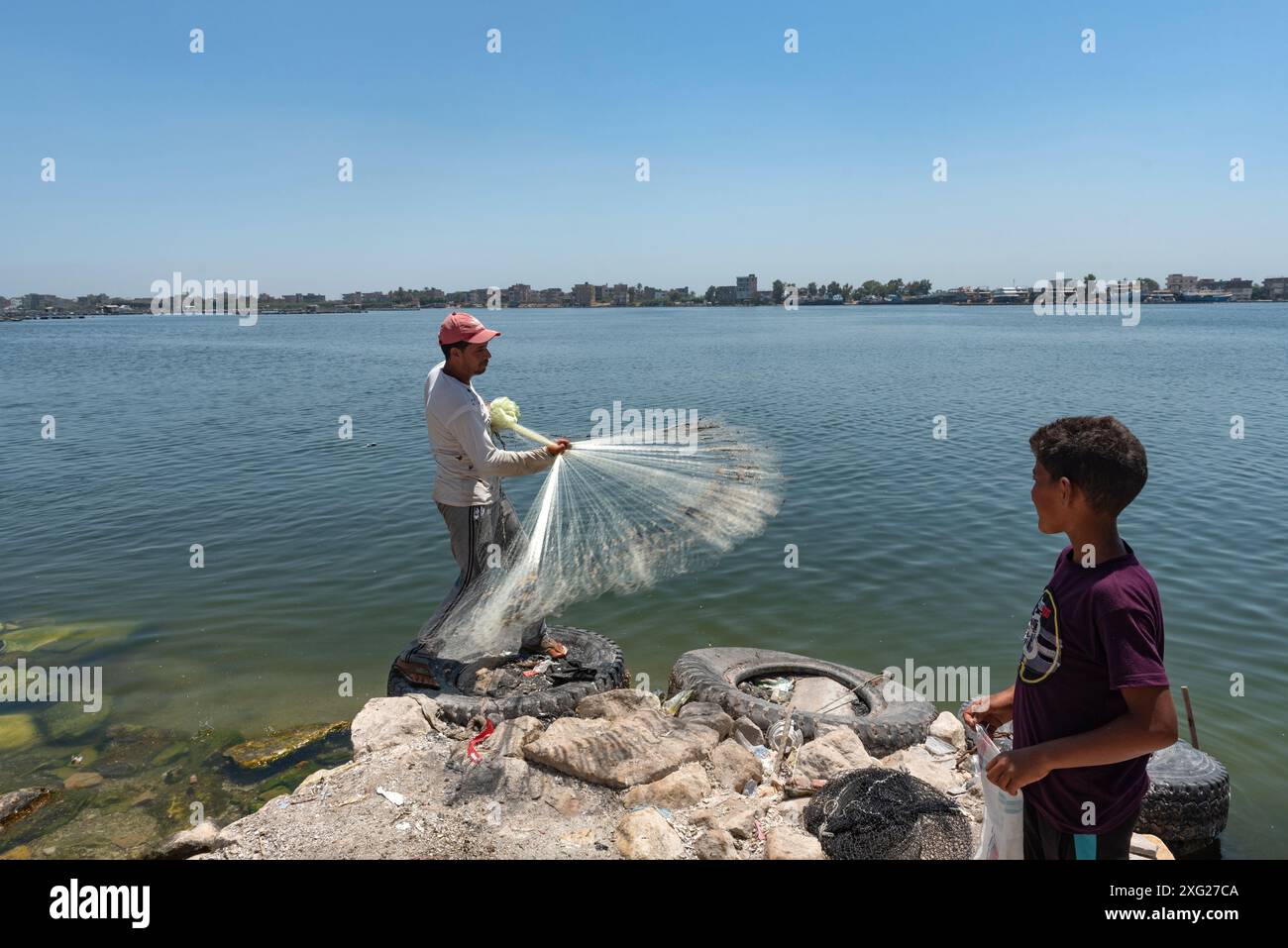 A local Egyptian fisherman castes his weighted net into the River Nile ...