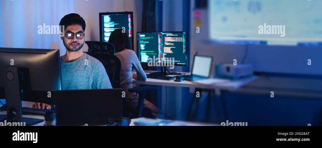 Asian software developers working on multiple screens displaying code ...