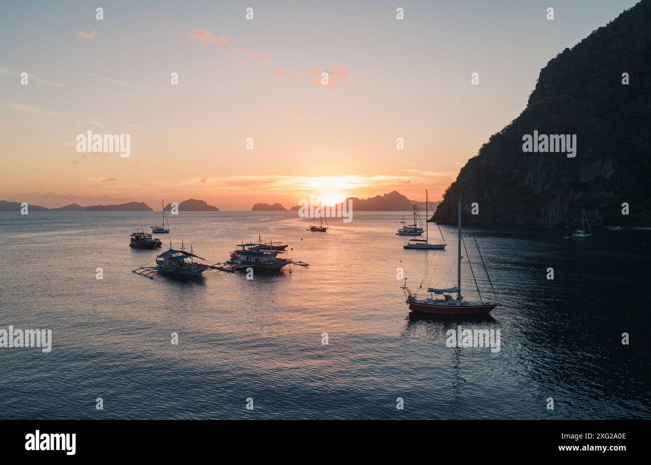 Aerial view of cliffs in the sea, yachts are sailing nearby, mountains ...