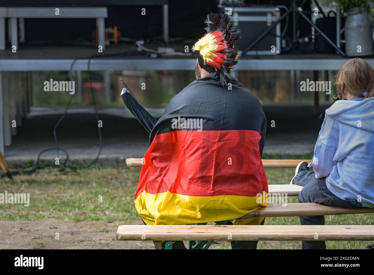 Soccer fan from behind wearing flag and wig in the German colors ...