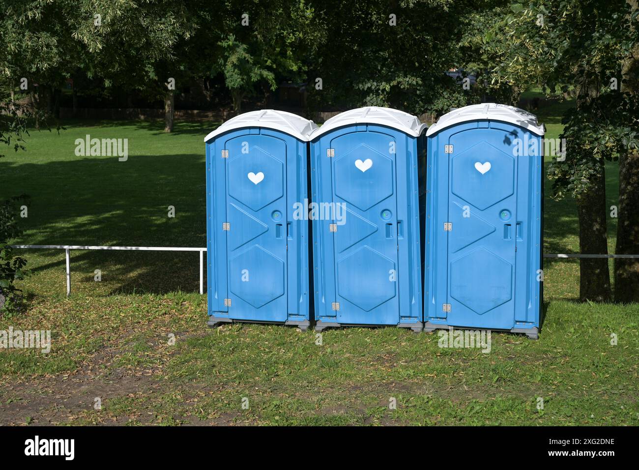 Three blue mobile toilets in the park at an Open-Air festival event on ...