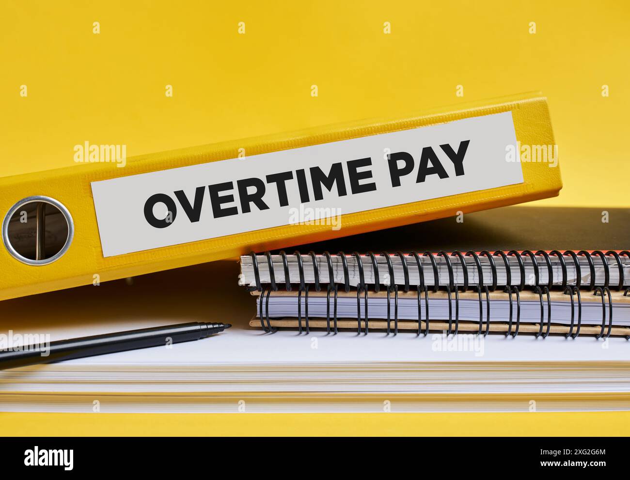Overtime pay written on the label of a yellow binder on the office desk ...
