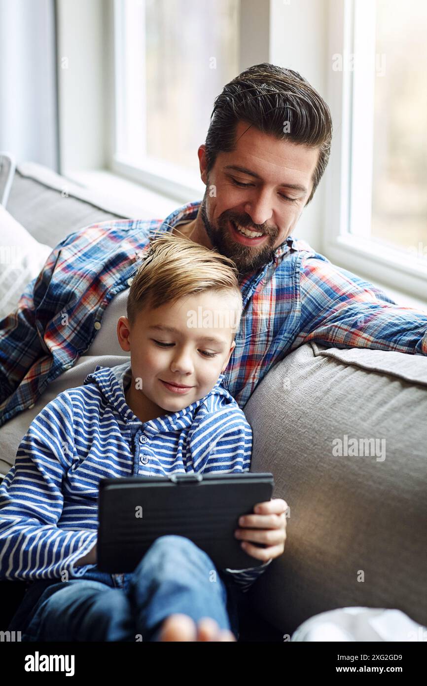 Father, son and tablet on sofa with internet for educational gaming ...