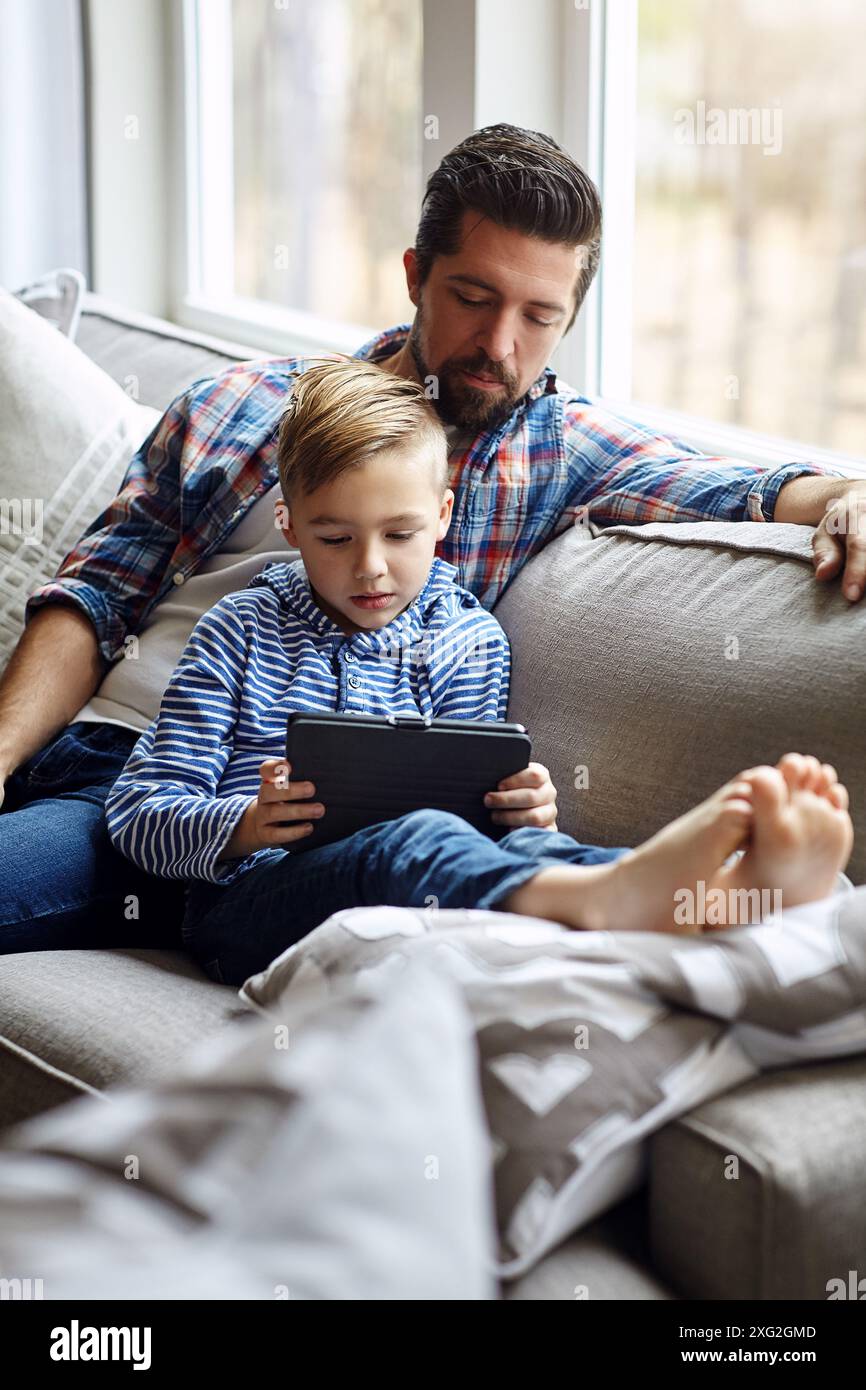 Dad, son and home on couch with tablet, family together and browsing ...
