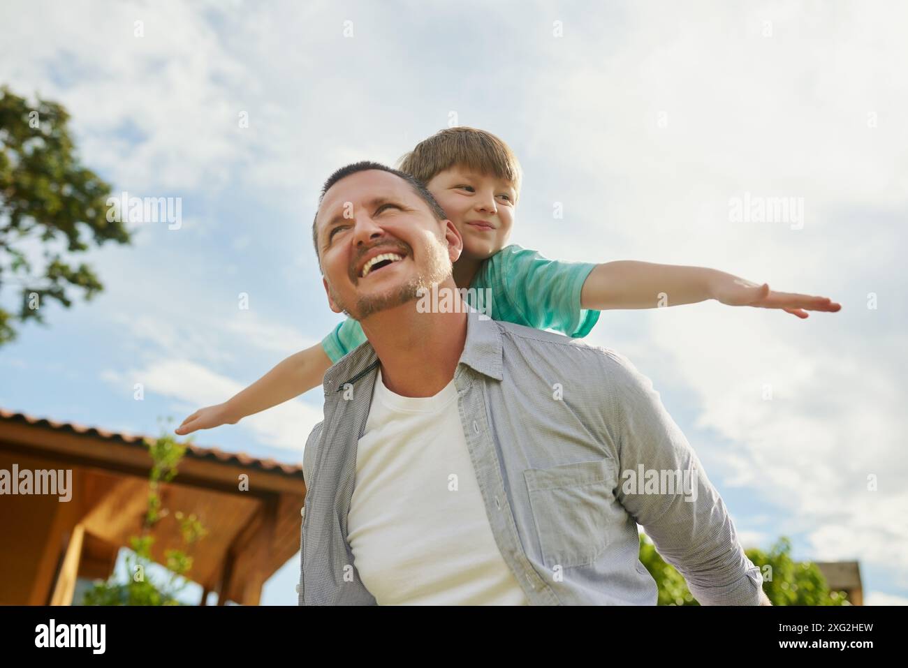 Father, kid and piggyback in backyard of new home, love and bonding to ...
