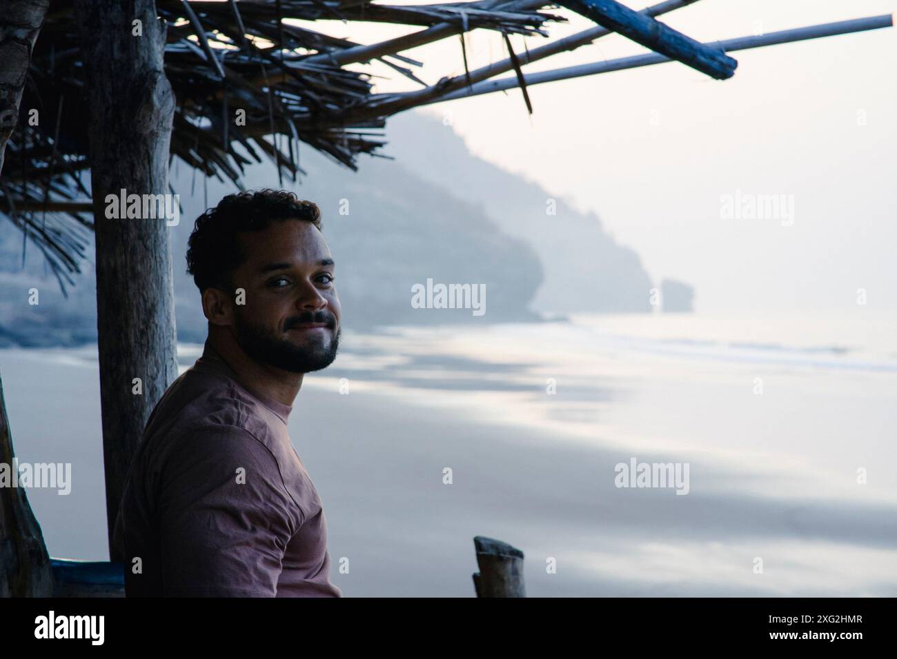 A man smiles warmly at the camera, enjoying the serene atmosphere of a ...