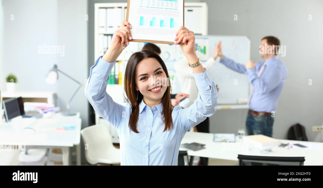 Portrait of woman lift document over head, celebrate good deal ...