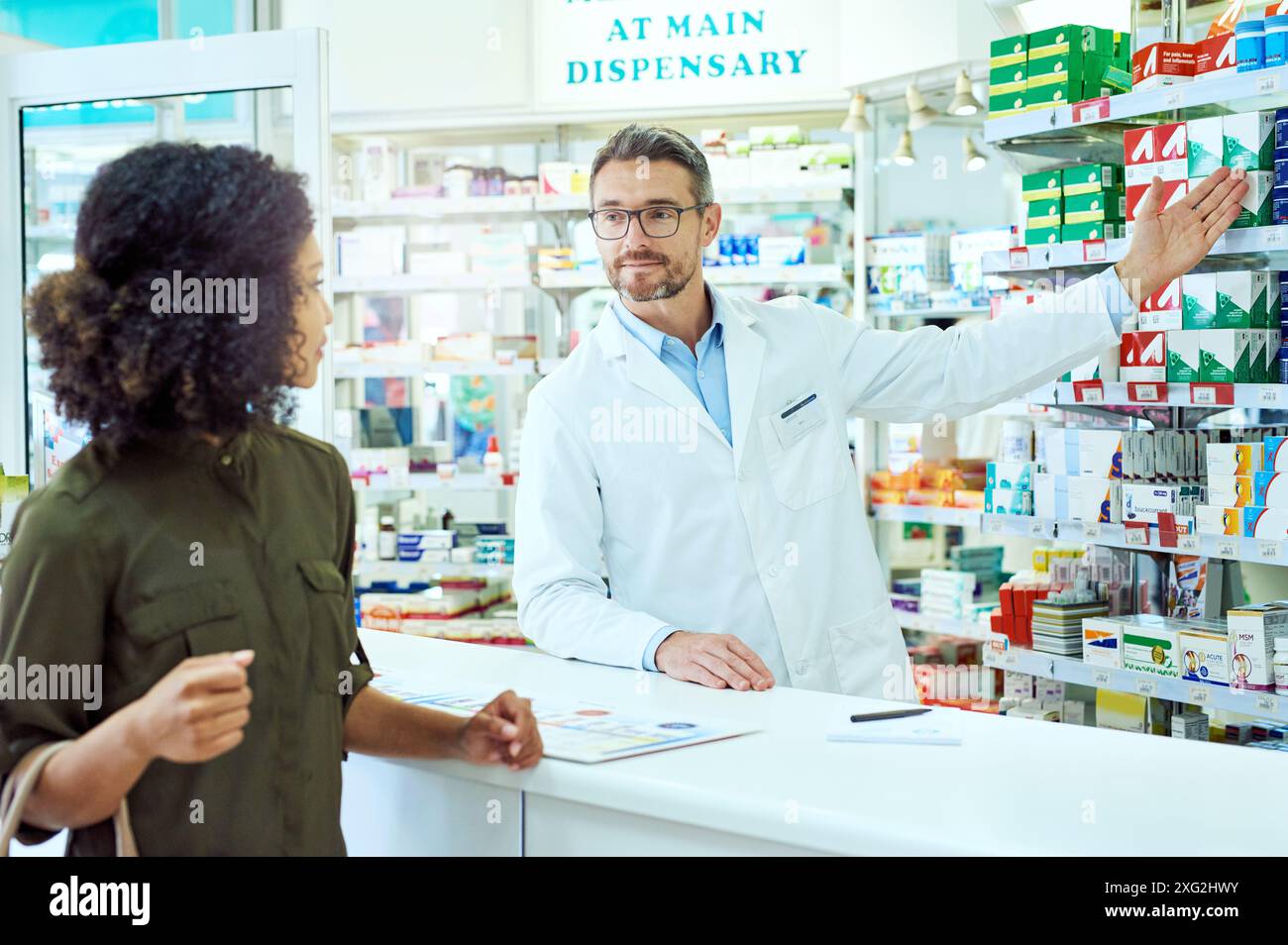 Man, pharmacist and shelf with customer for medication, option or ...