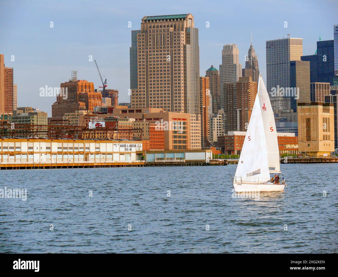 A sailing yacht sails up the Hudson River off Pier 40, New York USA ...