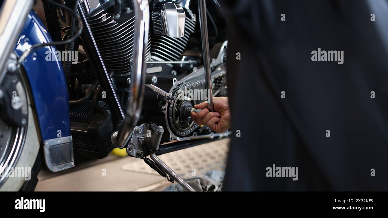 Professional mechanic fixing part of motorbike transport with wrench ...