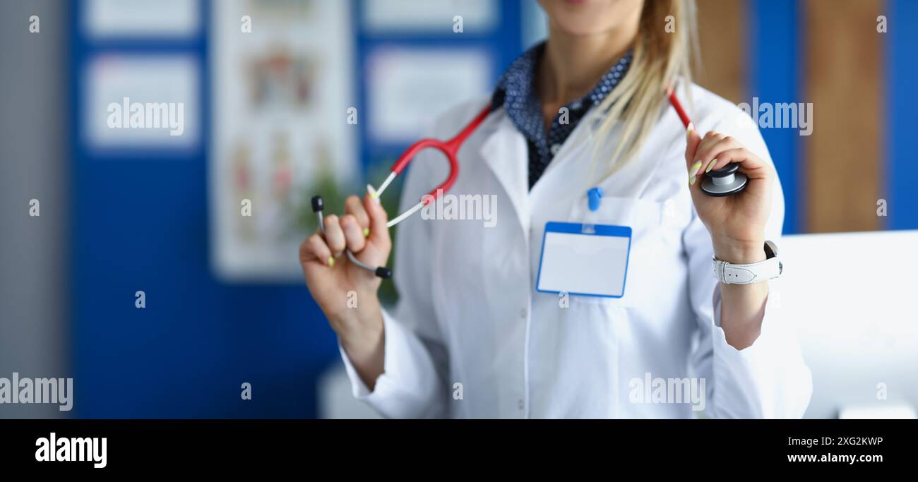 Female medical worker in white uniform posing with stethoscope on neck ...