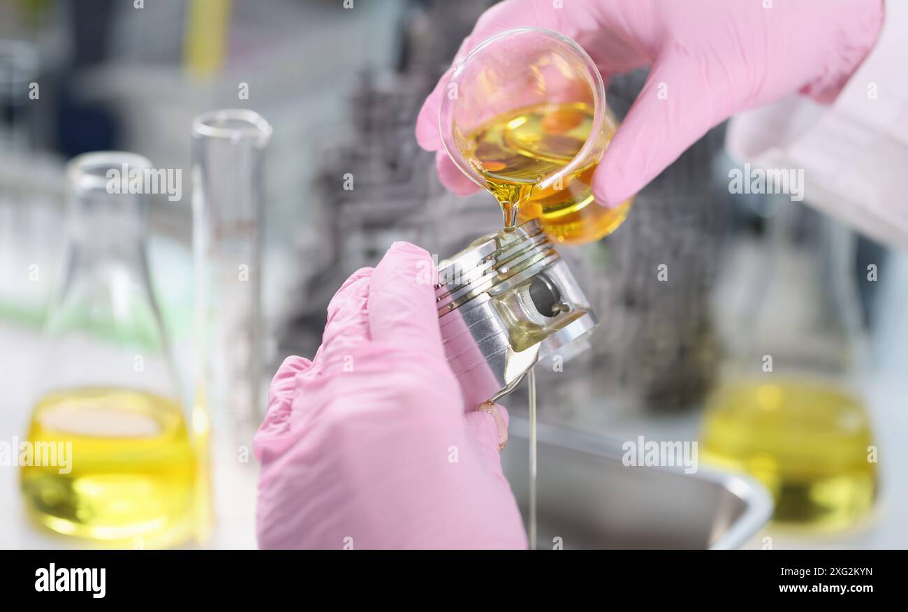 Mans hand in rubber gloves holding car part and pours lubricating oil ...