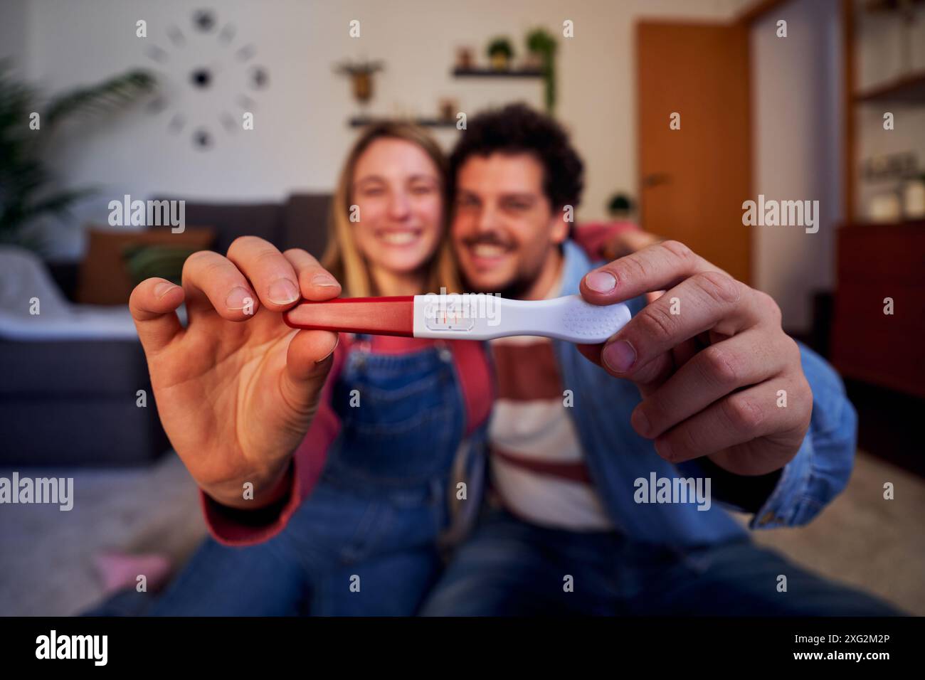Cheerful caucasian couple at home showing a positive pregnancy tes to ...