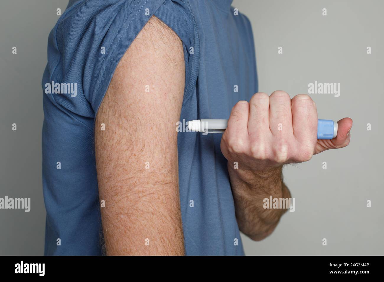 Man injecting insulin in hers arm Stock Photo - Alamy
