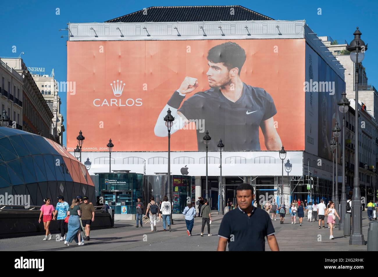 June 16, 2024, Madrid, Spain: Pedestrians walk past a large billboard ...