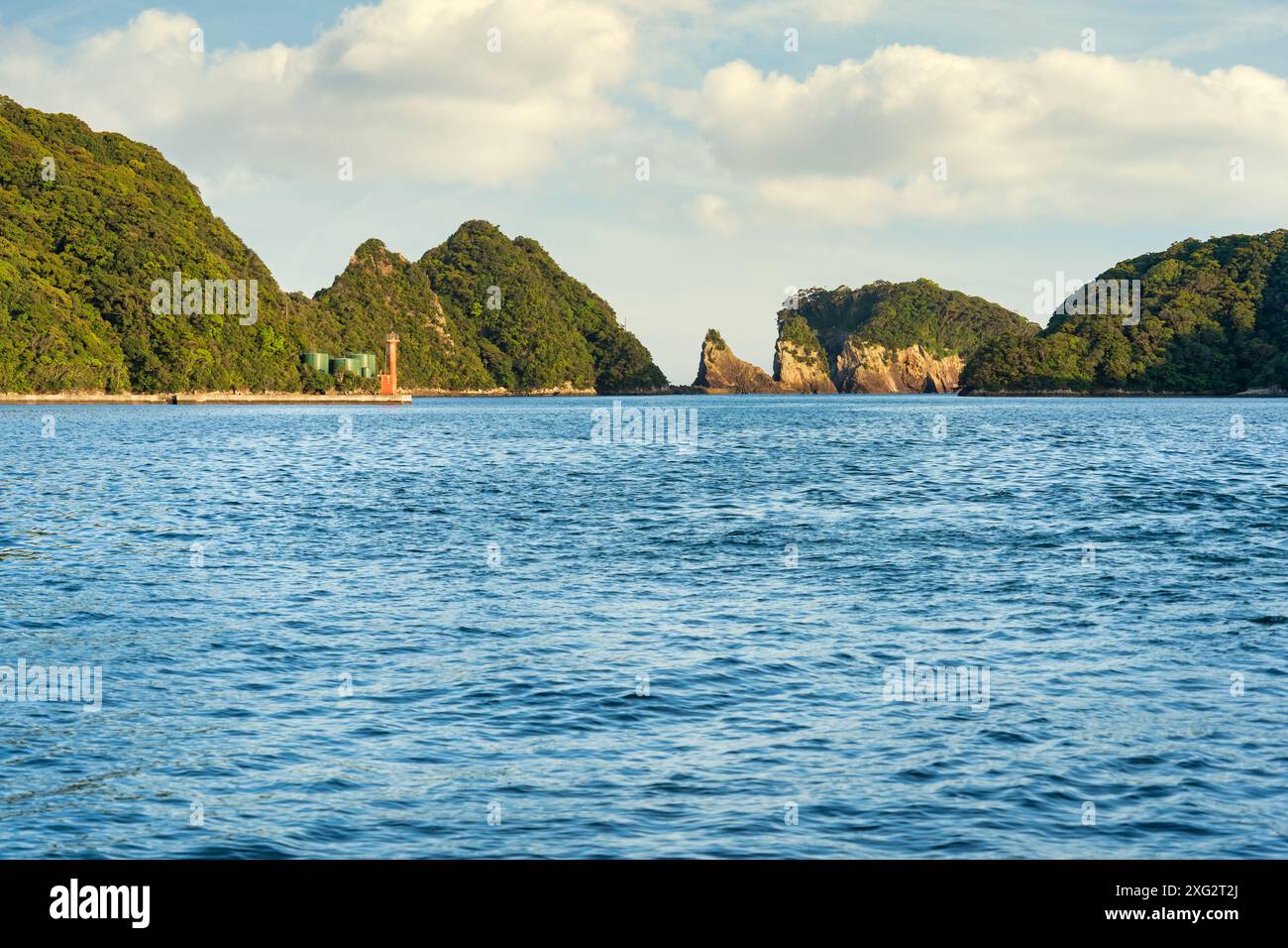 Dramatic rock formations covered with lush greenery on the coast of ...