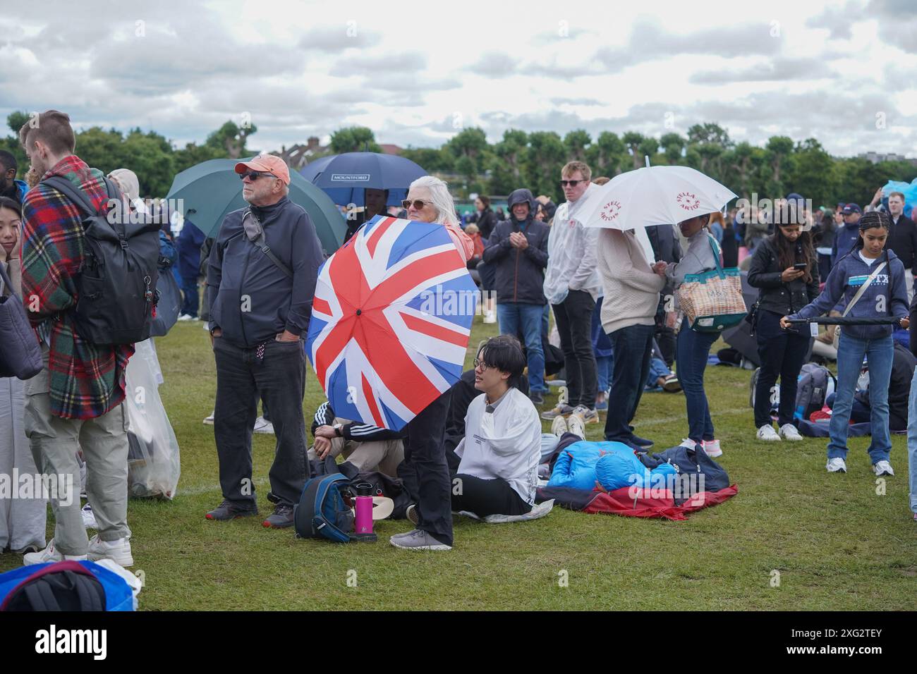 Wimbledon, London UK 6 July 2024. Tennis fans queuing with umbrellas ...