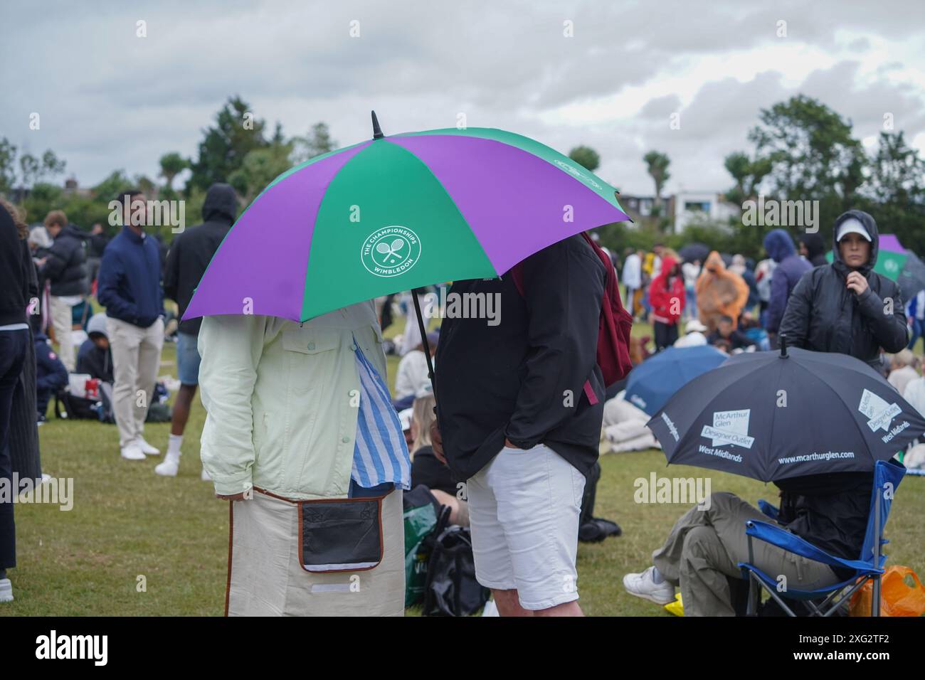 Wimbledon, London UK 6 July 2024. Tennis fans queuing with umbrellas ...