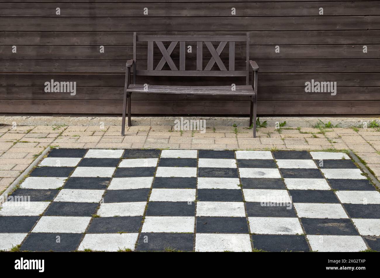 Place outdoors to play chess. Chessboard and an empty wooden bench ...