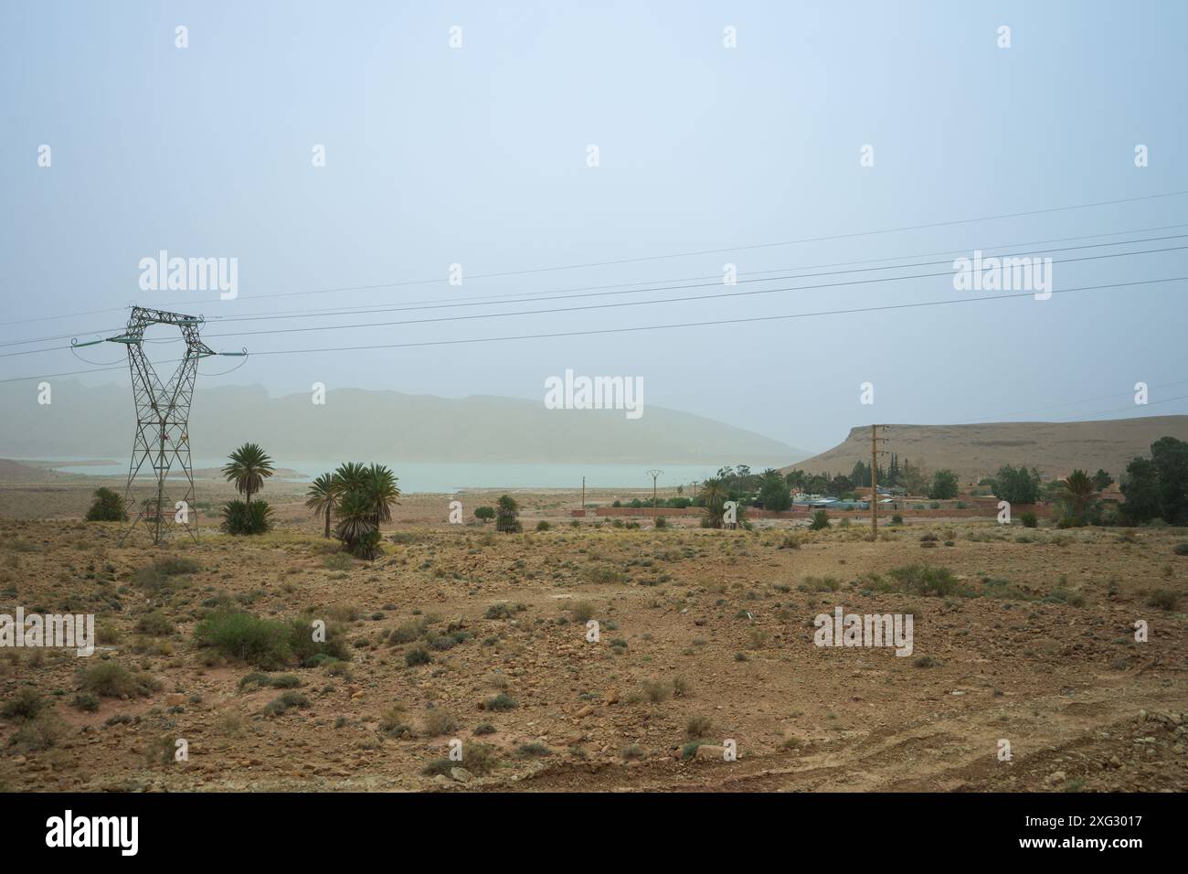 Panoramic view of Al Wahda Dam, with towering power lines and sparse ...