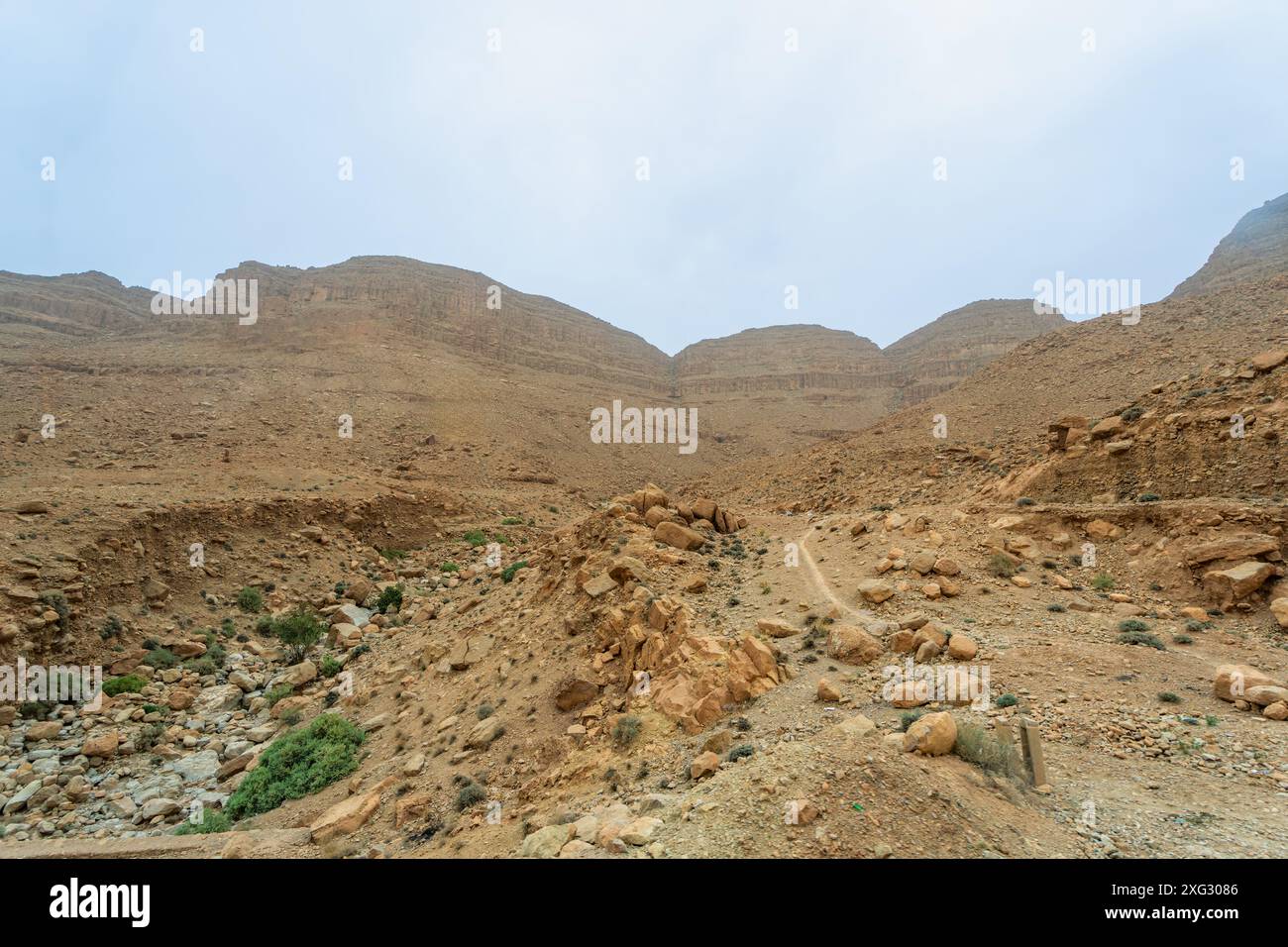 Steep rocky slopes with scattered boulders and sparse vegetation ...