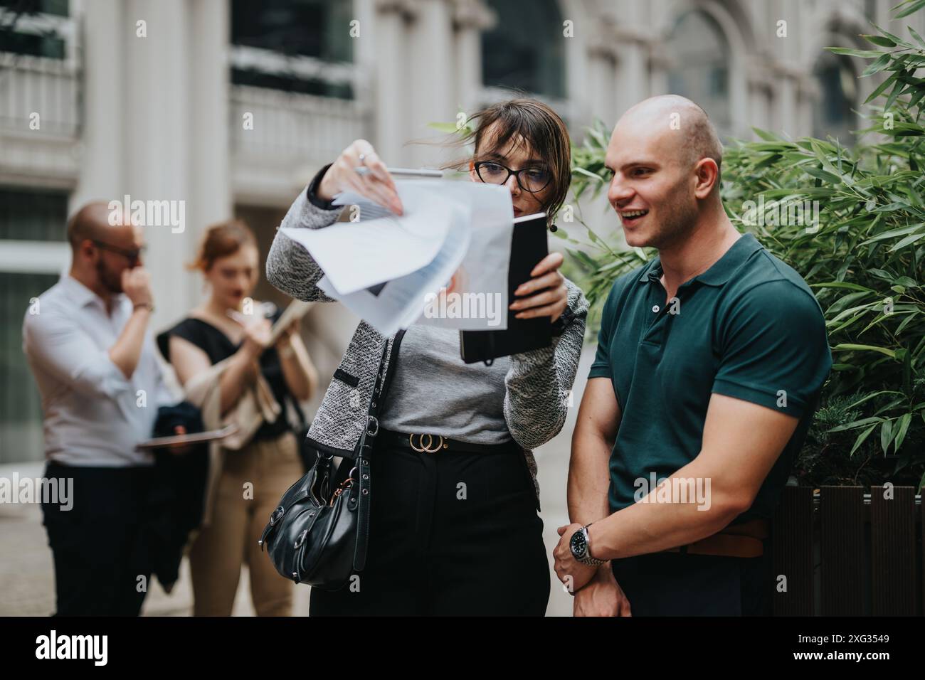 Group of diverse colleagues collaborating outdoors on a work project ...
