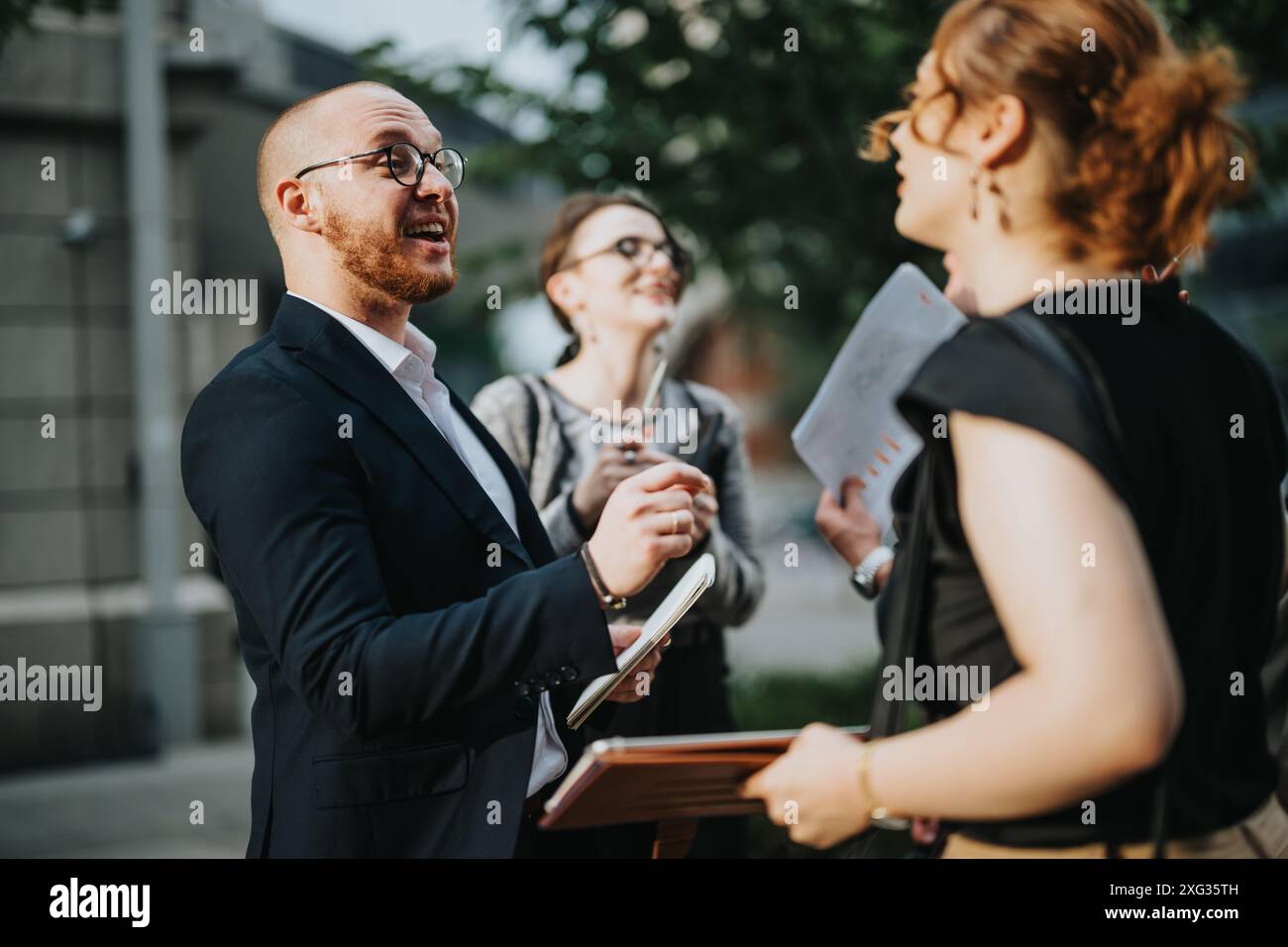 Business professionals having an informal meeting outdoors with a ...