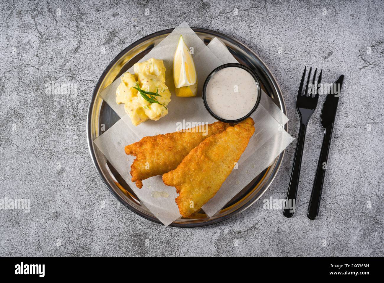 Deep fried coated fish fillet with potato salad on stone table Stock ...