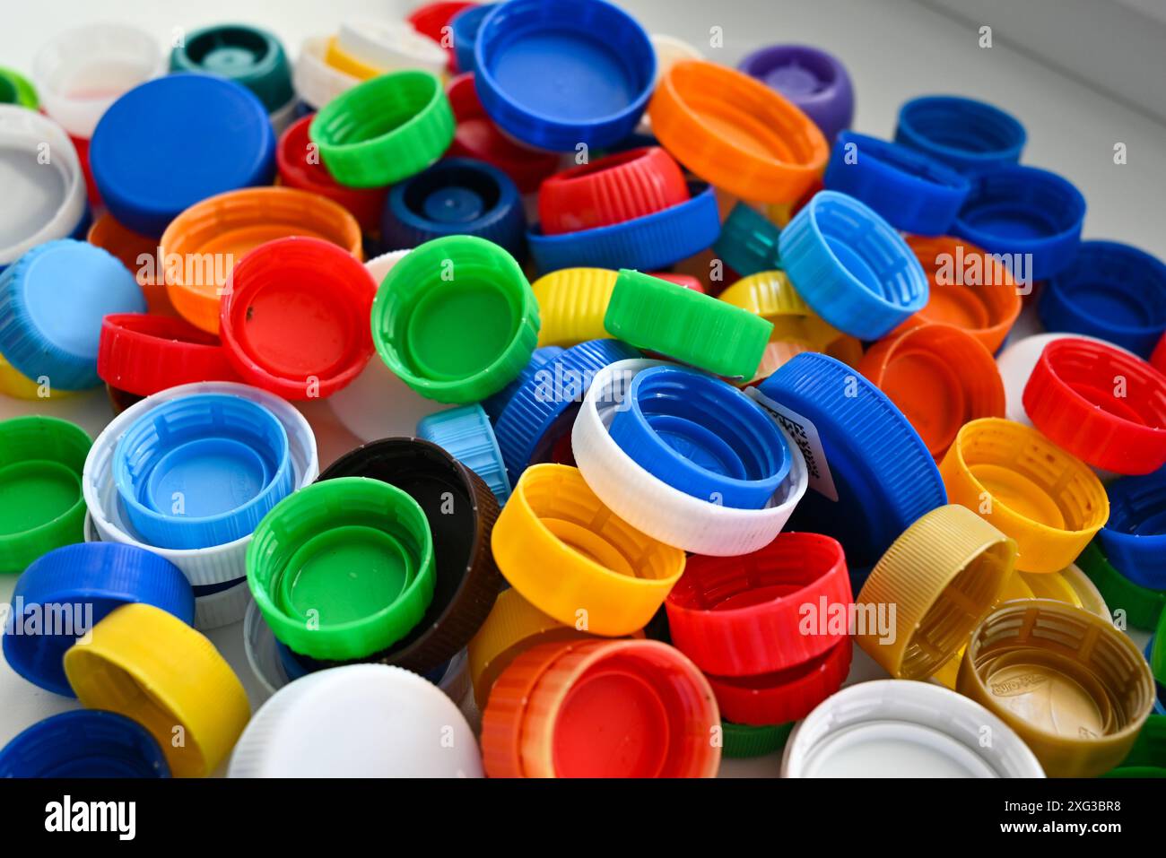 Multi-colored plastic caps of different sizes from plastic bottles are ...