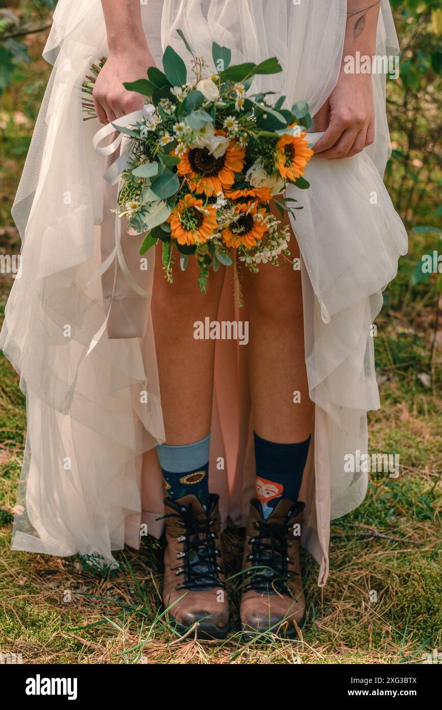 A bride in a beautiful dress stands in the middle of the forest and ...