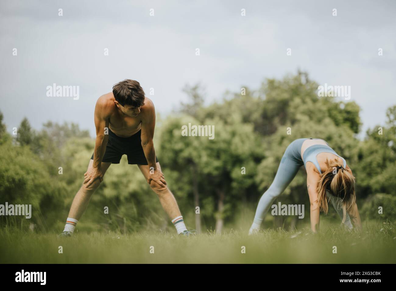 Outdoor fitness couple stretching in nature during workout routine ...