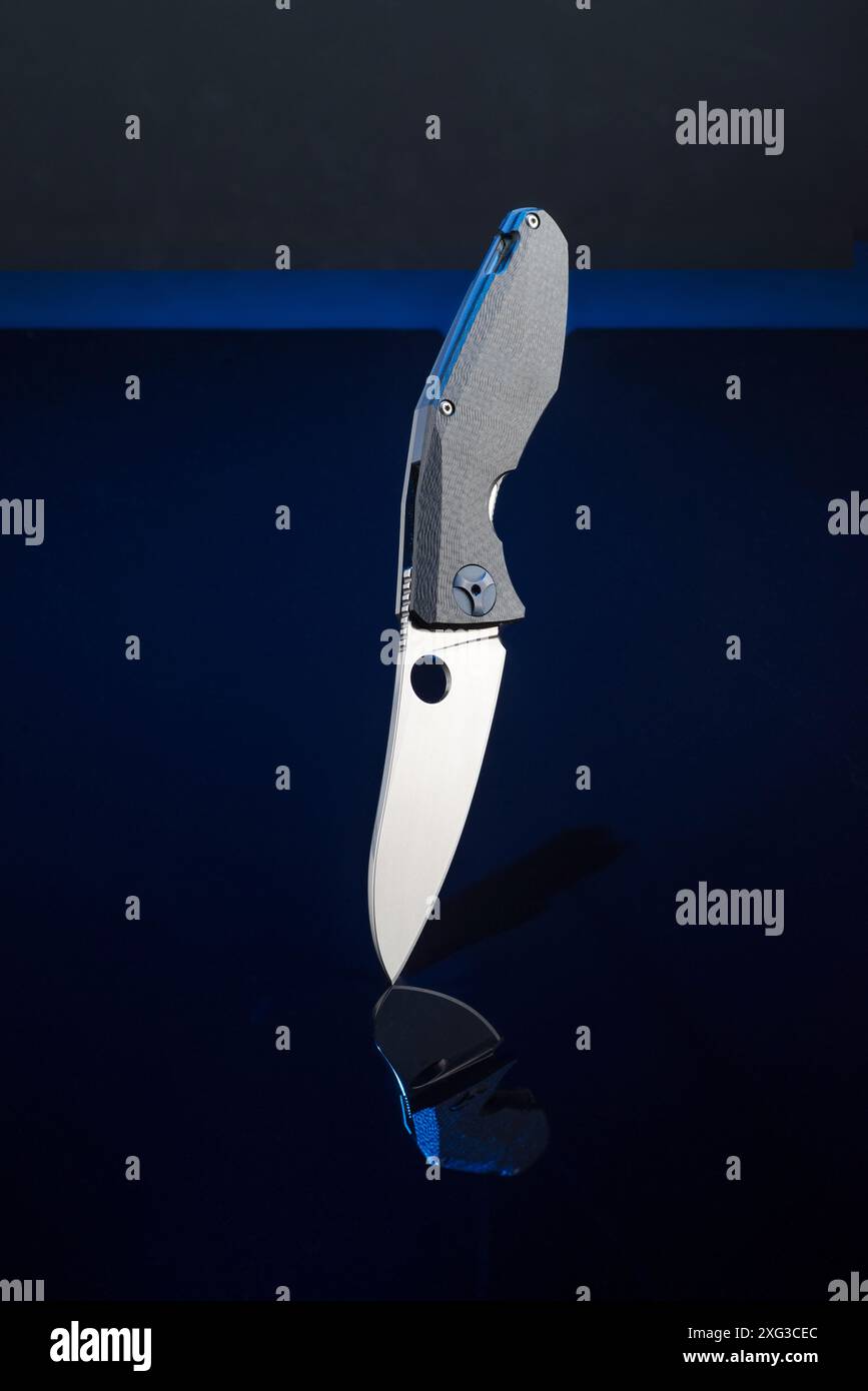 Premium quality folding pocket knife. The knife and its reflection ...