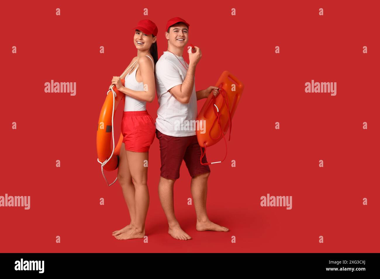 Lifeguards with ring buoy and rescue tube on red background Stock Photo ...