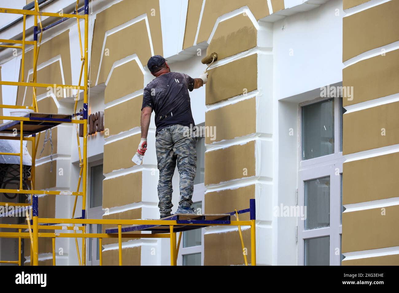 Worker repair the building wall standing on lifting platform. Builder ...