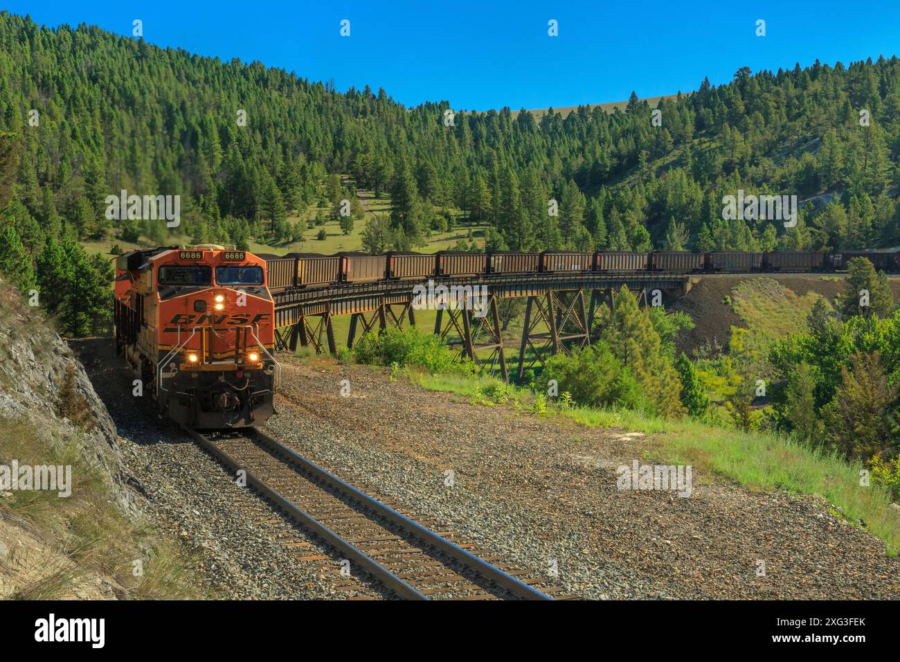 coal train heading to mullan pass on the continental divide over a trestle near austin, montana ...