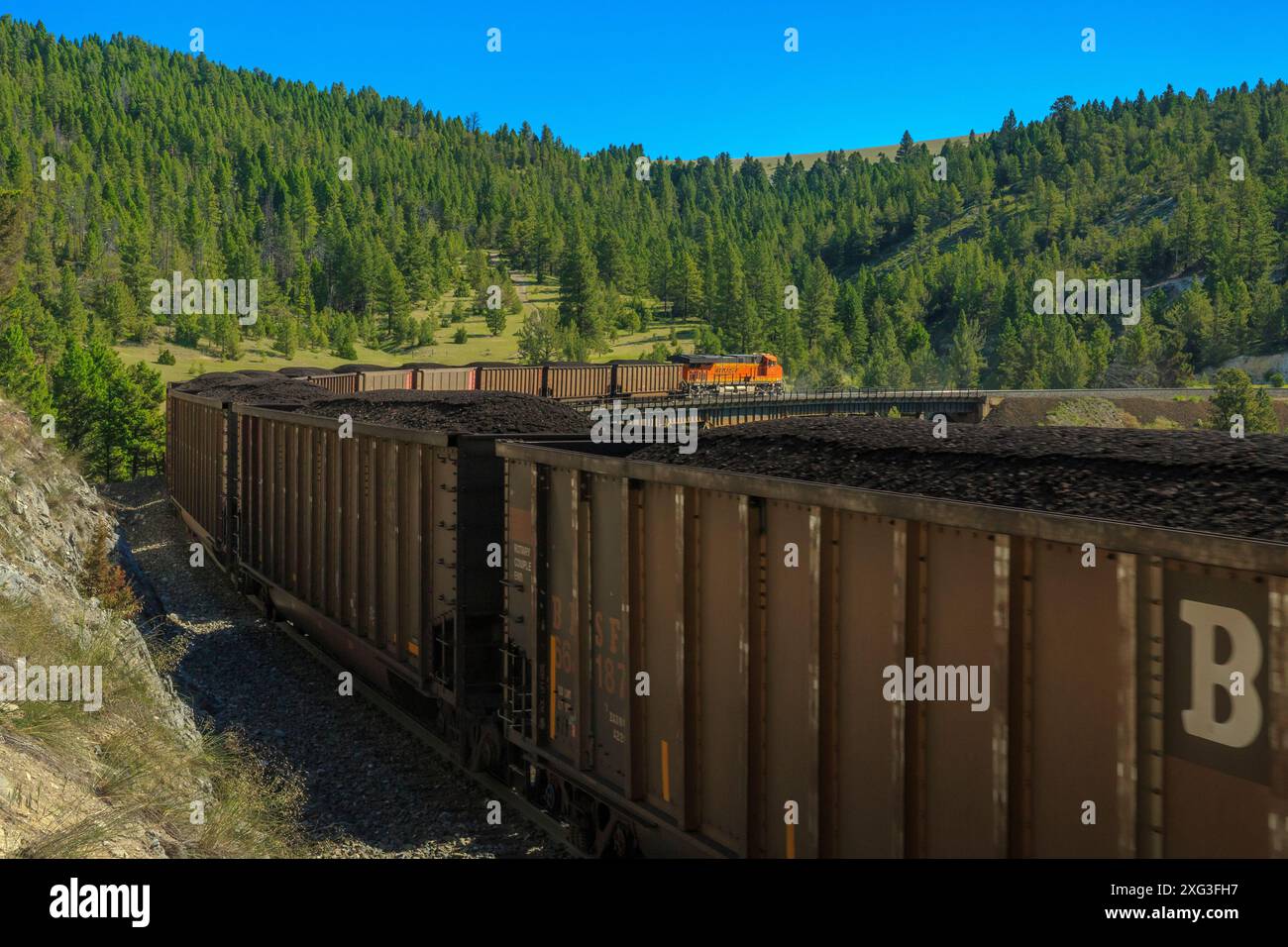 coal train heading to mullan pass on the continental divide over a trestle near austin, montana ...