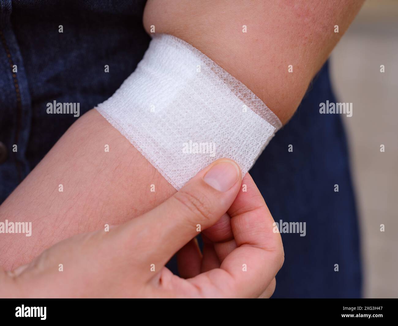 A woman putting a bandage on her hand after having blood taken Stock ...