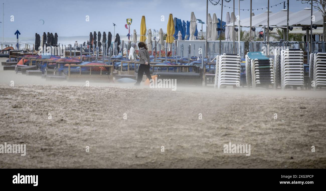 SCHEVENINGEN - Walkers have difficulty with the wind along the beach of ...