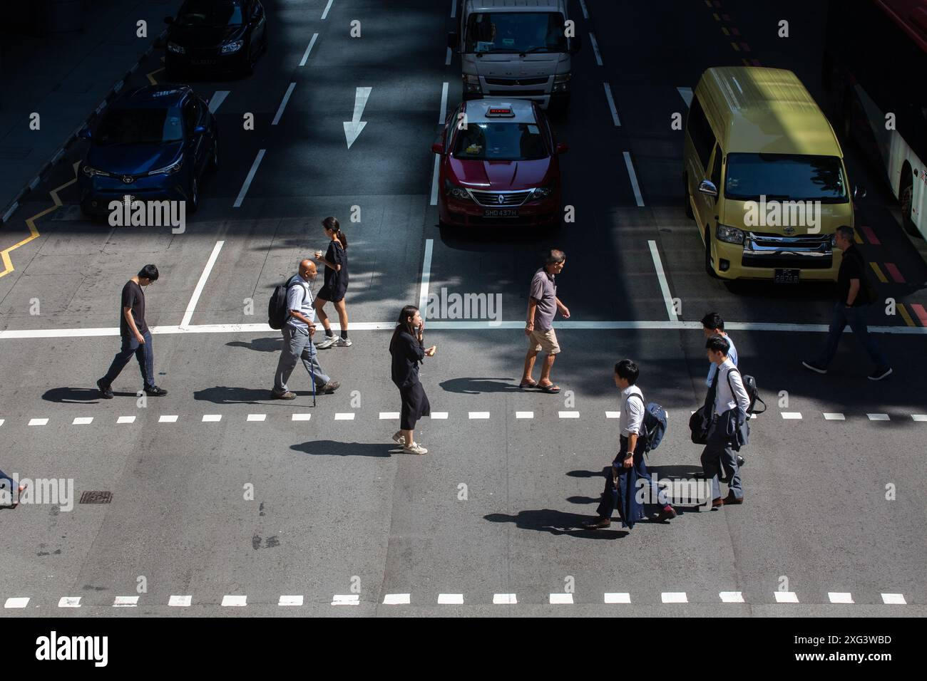 Aerial view of pedestrian crossing the road under the sunny hot weather ...