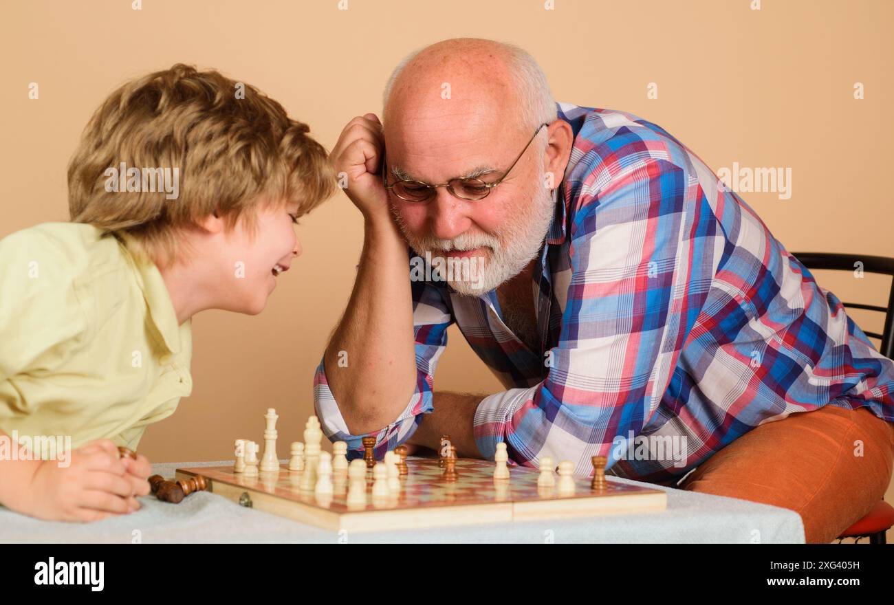 Chess competition. Child boy play chess with grandfather. Board games ...