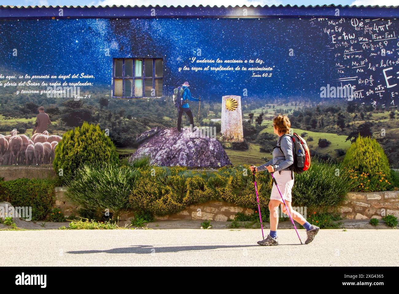 Pilgrim walking past a wall mural on the Camino de Santiago way of St ...