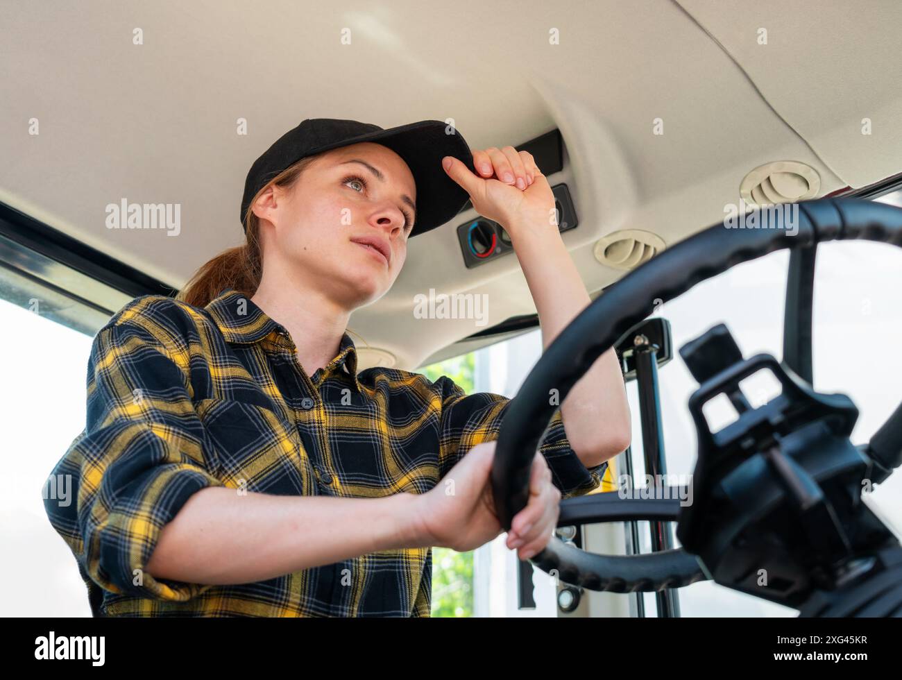 Female farm tractor driver operates agricultural machinery Stock Photo ...