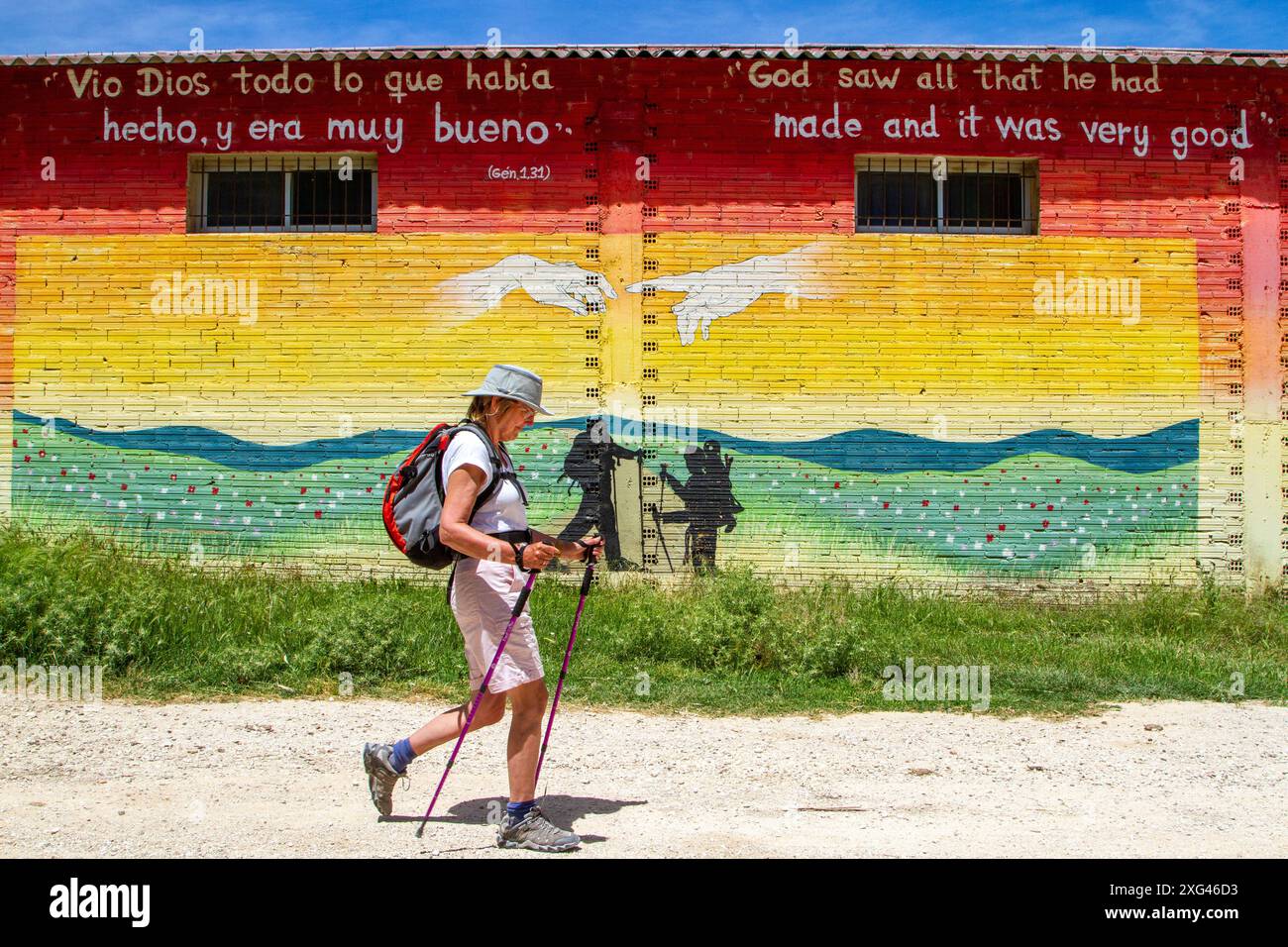 Pilgrim walking past a mural on the Camino de Santiago the way of St ...
