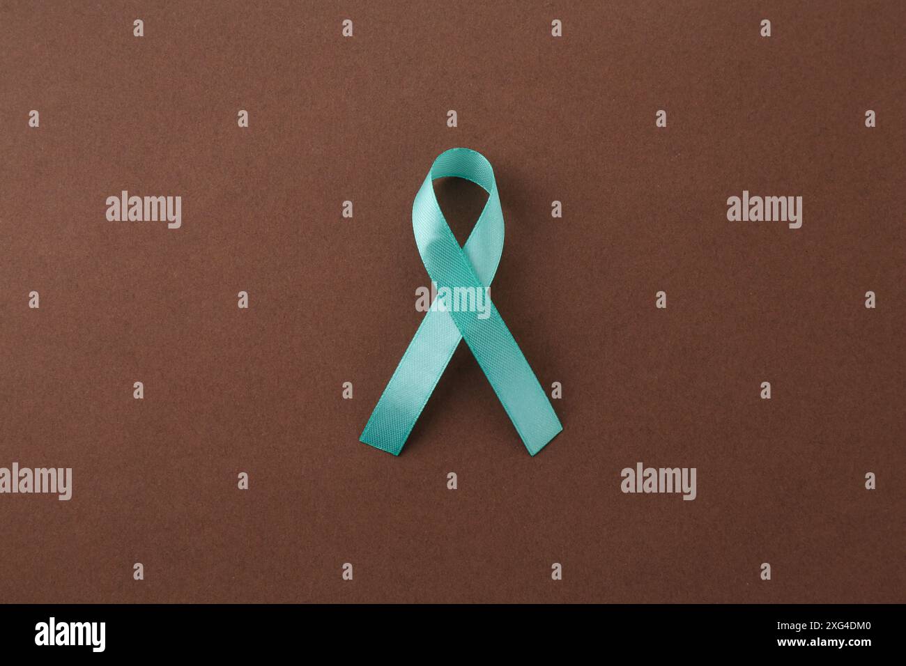 Turquoise awareness ribbon on brown background, top view Stock Photo ...
